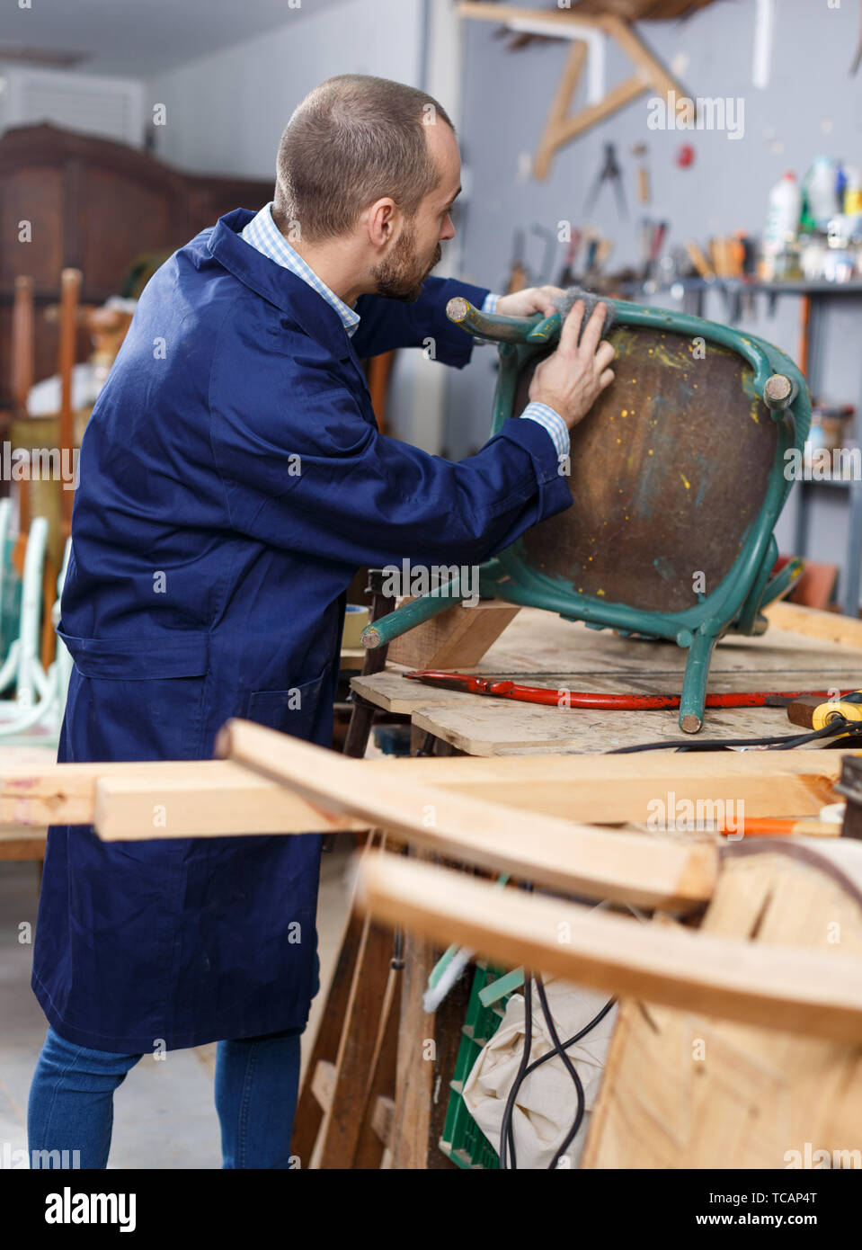 Furniture restorer renovation antique chair in his woodwork studio ...