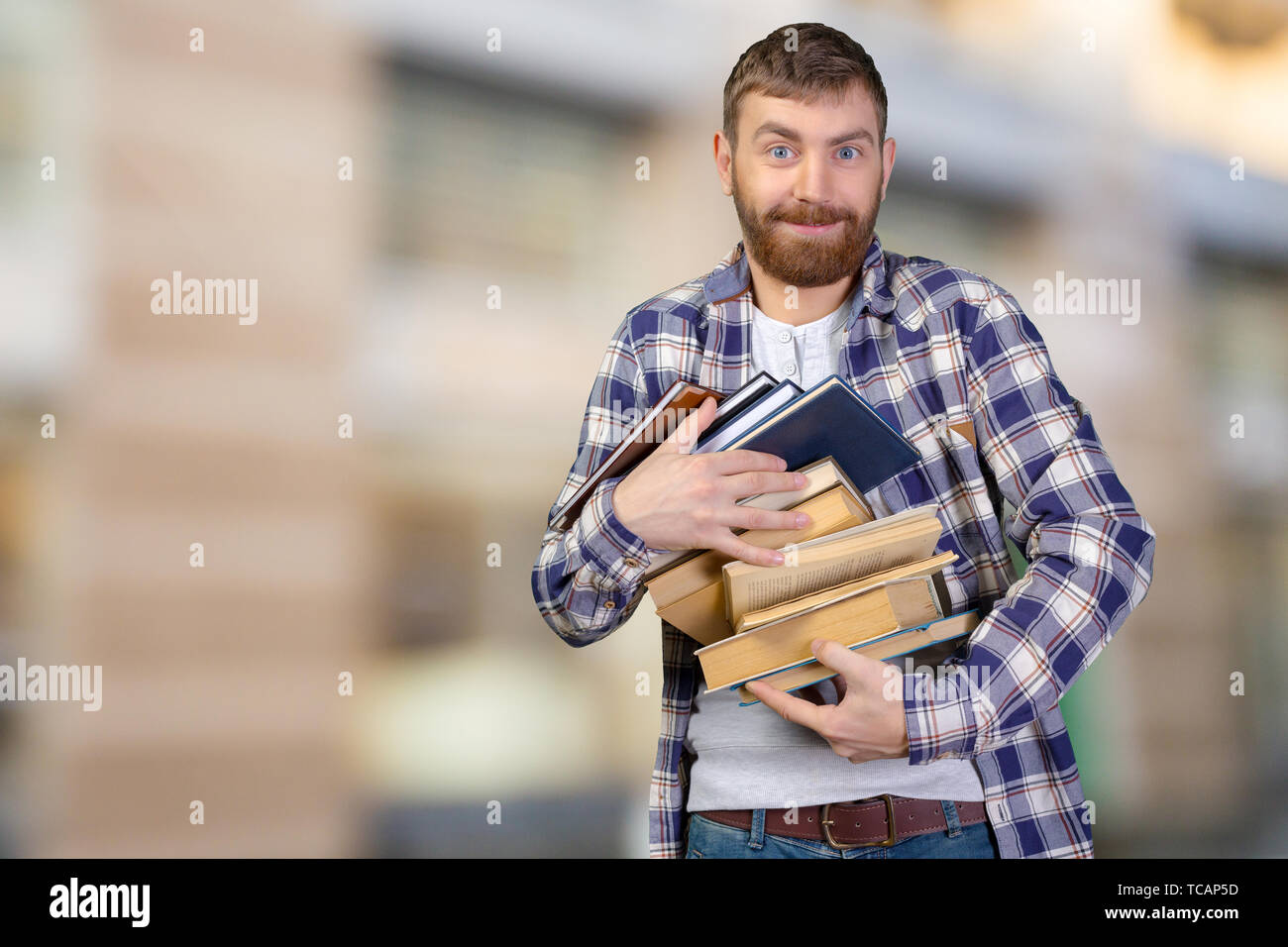 Young Man Holding Stack Of Books Stock Photo - Alamy