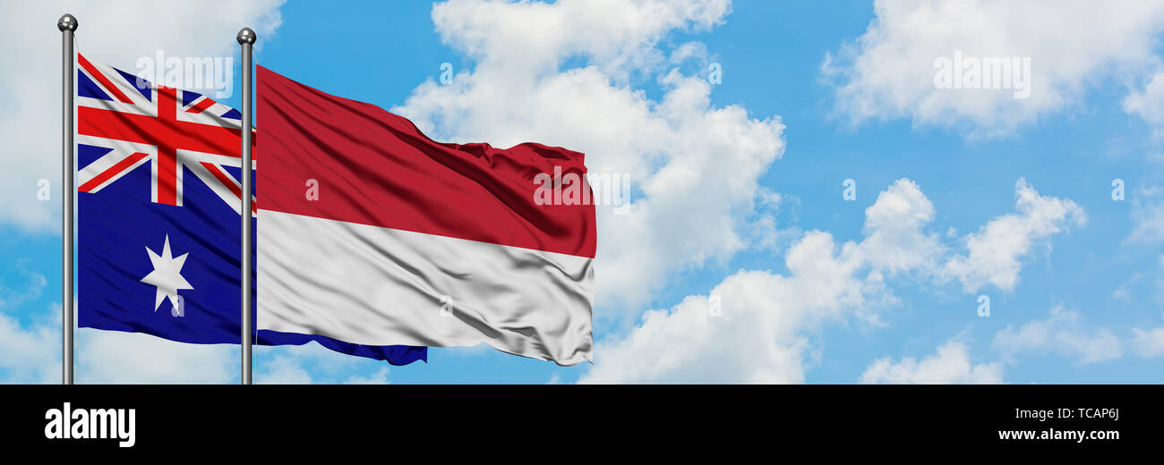 Australia and Monaco flag waving in the wind against white cloudy blue ...