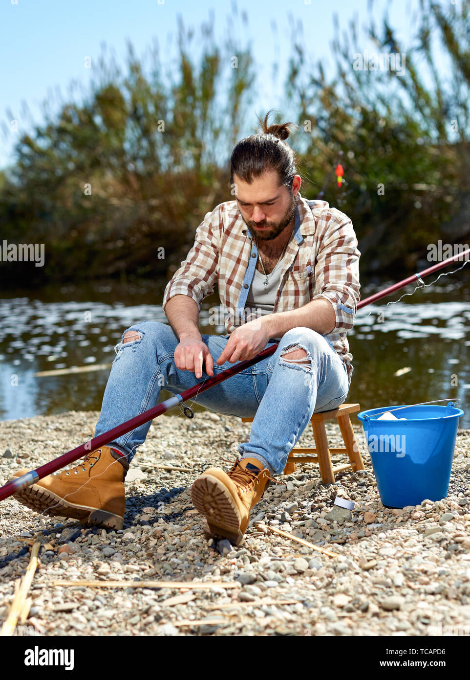 Bearded fisherman prepares fishing gear Stock Photo - Alamy
