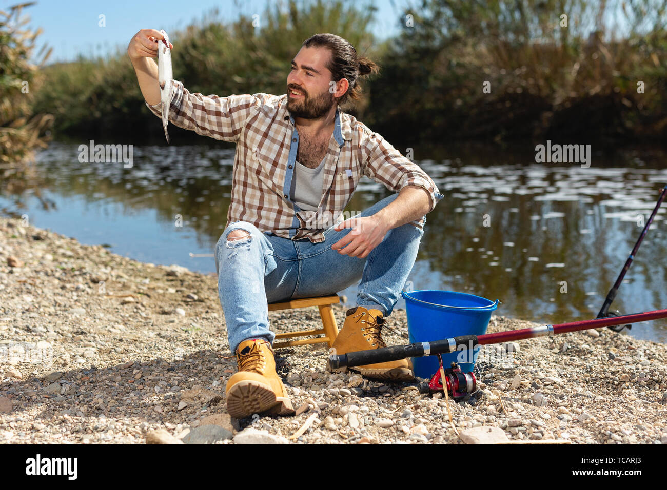 Adult male fisherman holding fish in his hands Stock Photo - Alamy