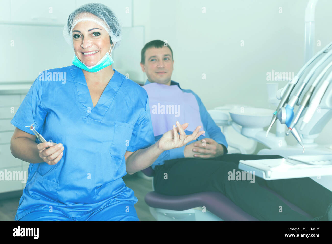 professional positive doctor woman and patient sitting in medical chair ...