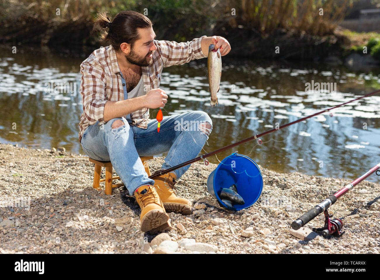 Adult male fisherman holding fish in his hands Stock Photo - Alamy