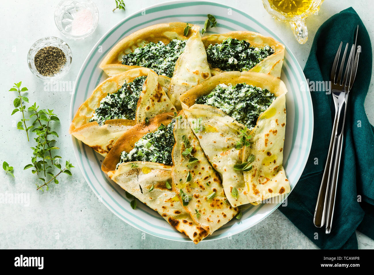 Traditional Italian pancakes crepes with spinach and ricotta on a ...
