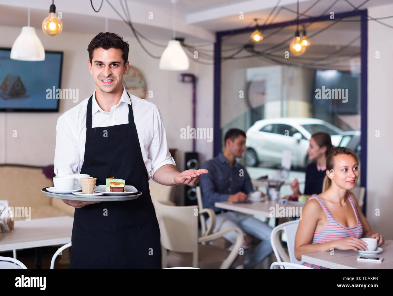 Positive male waiter welcoming hi-res stock photography and images - Alamy