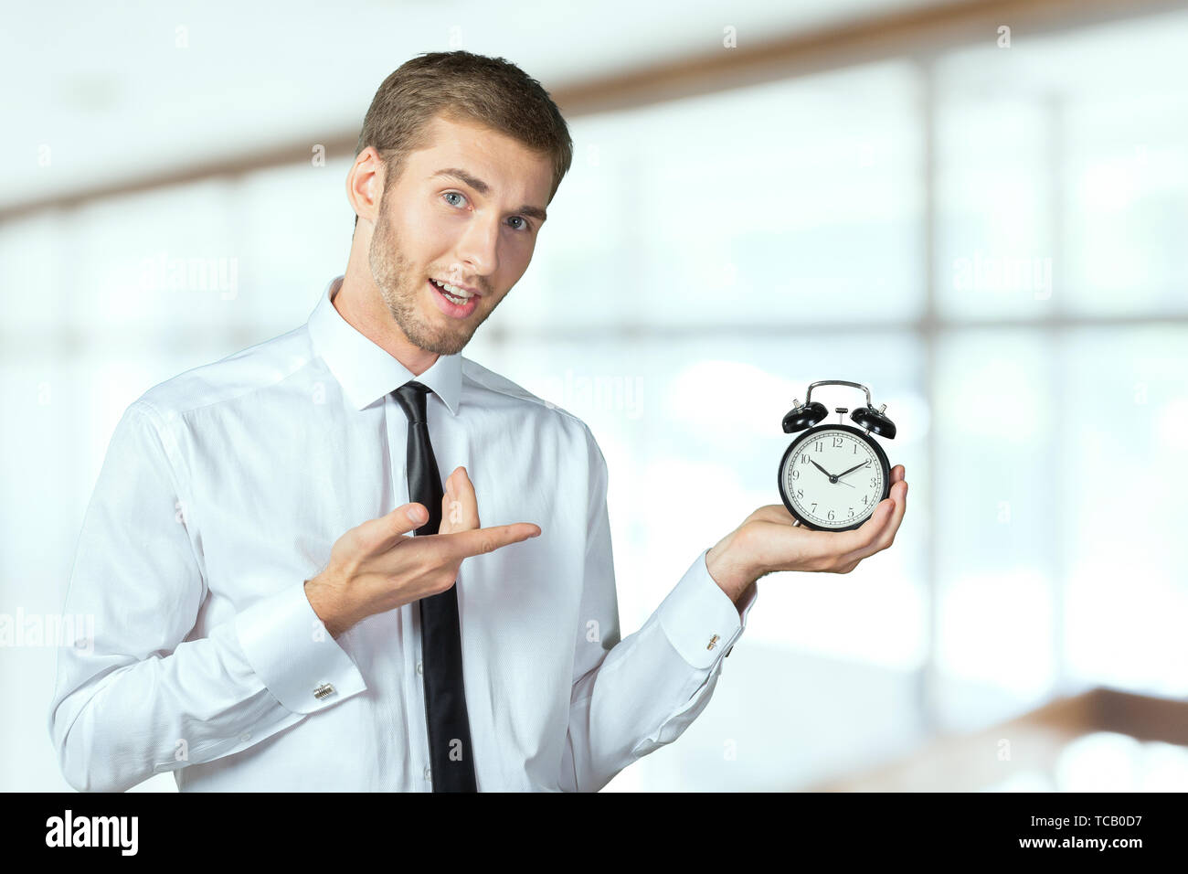Successful businessman in formal wear pointing at clock Stock Photo - Alamy