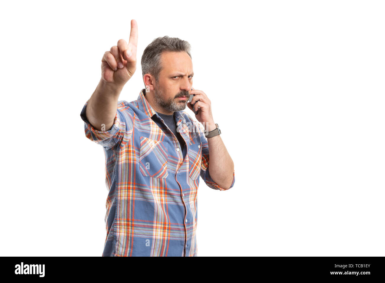 Busy man making wait gesture with index finger while talking on phone ...