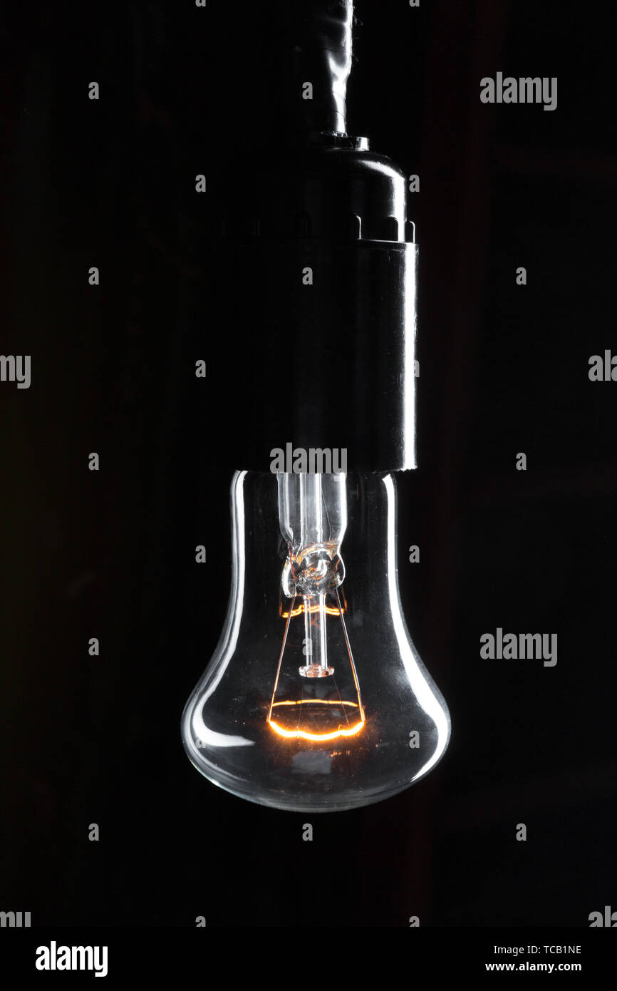 A classic Edison light bulb on dark background with space for text ...