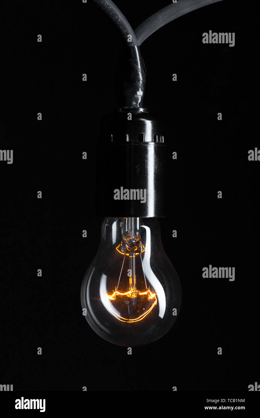 A classic Edison light bulb on dark background with space for text ...