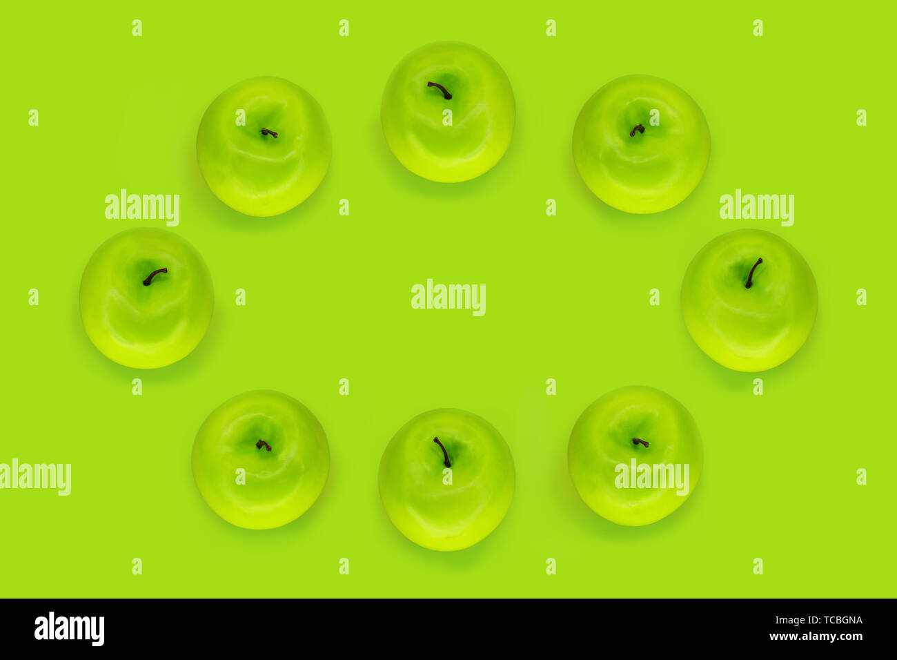 Oval frame of ripe juicy green apples on a green background with copy ...