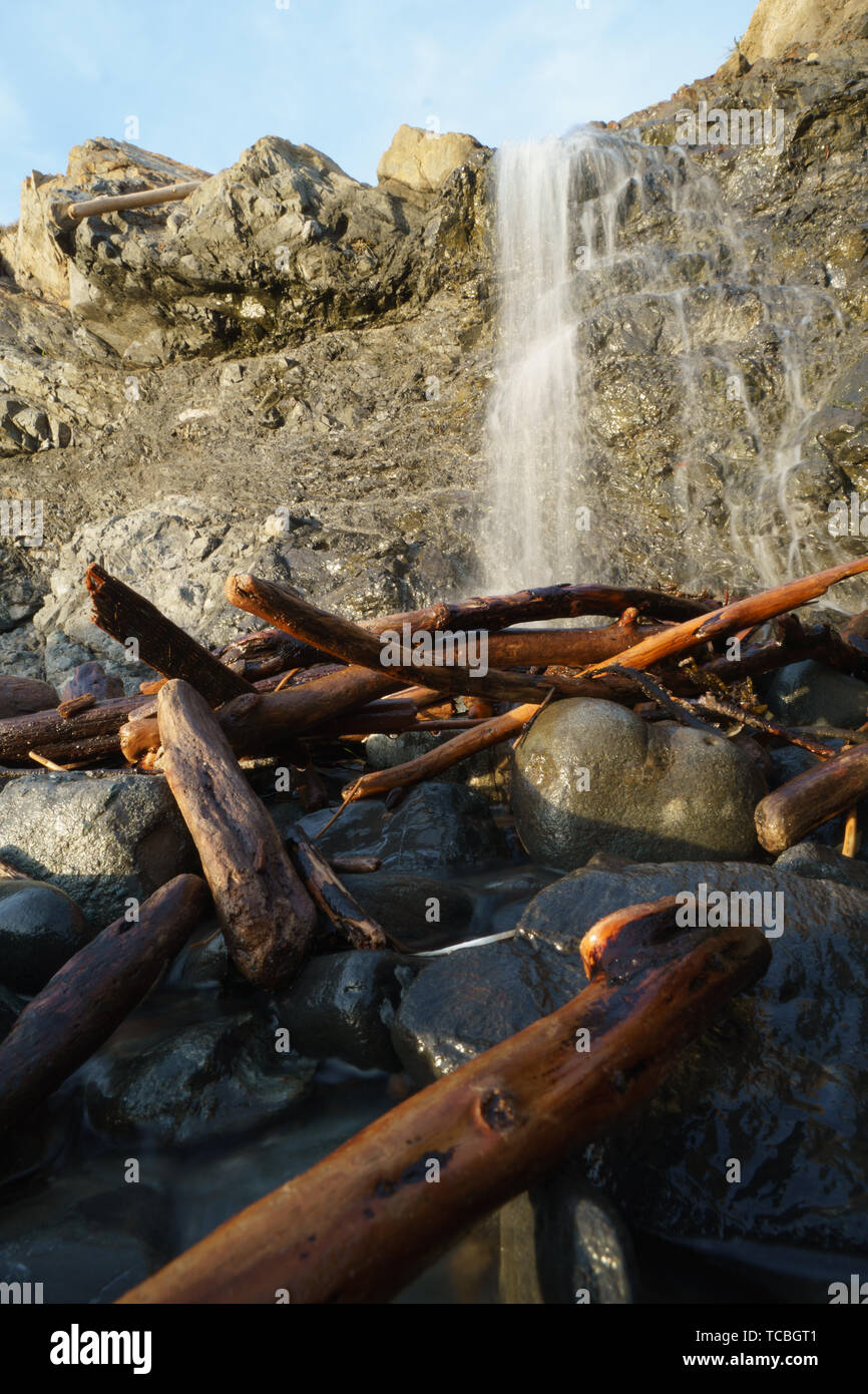 waterfall over cliff onto drift wood Stock Photo - Alamy