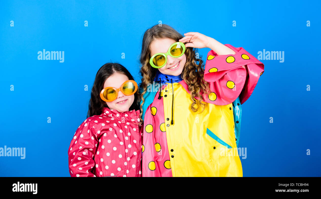 Small girls in raincoat and glasses. happy small girls in colorful rain ...