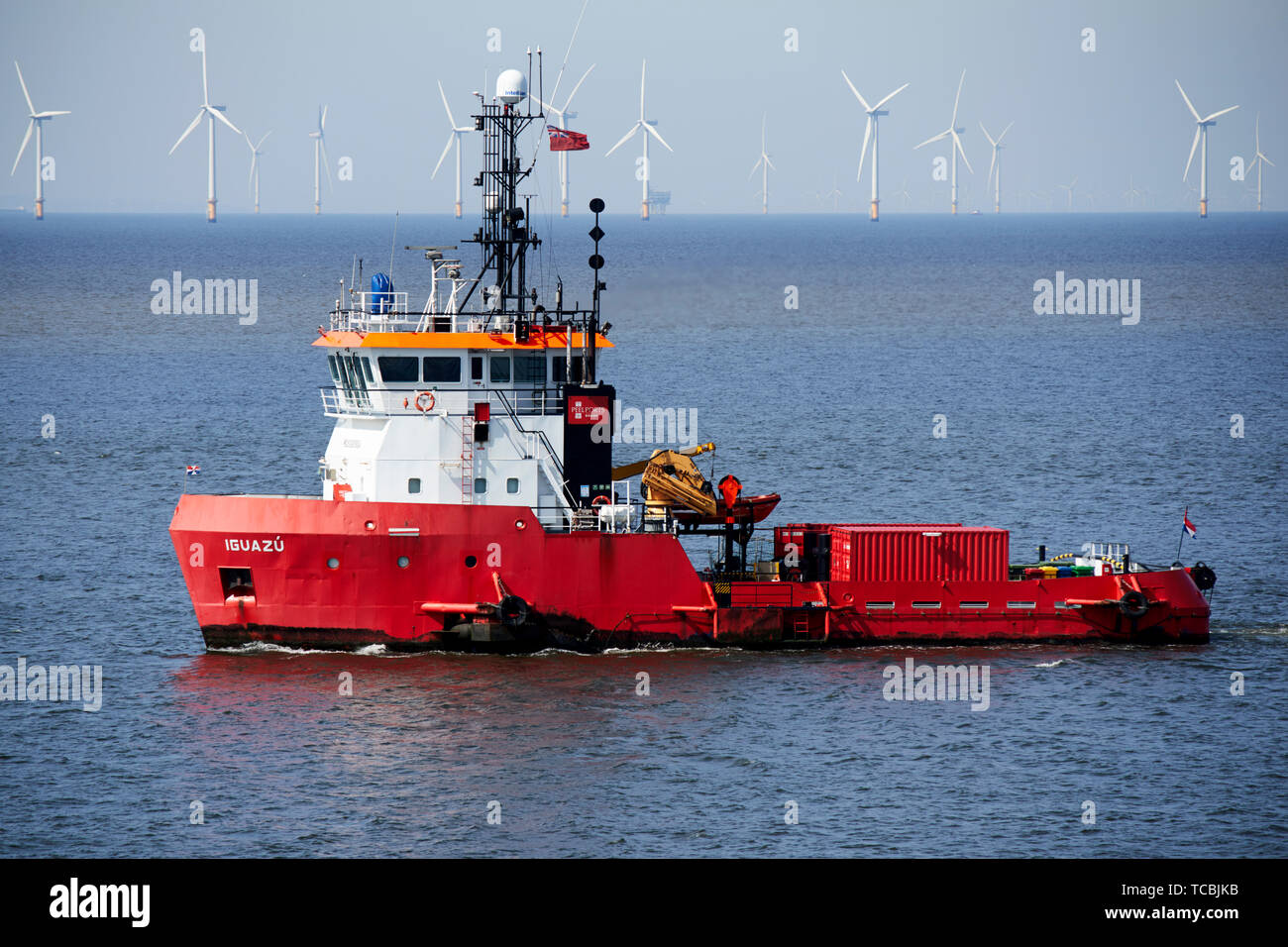 Iguazu tug water injection dredger sailing past wind farml in liverpool ...