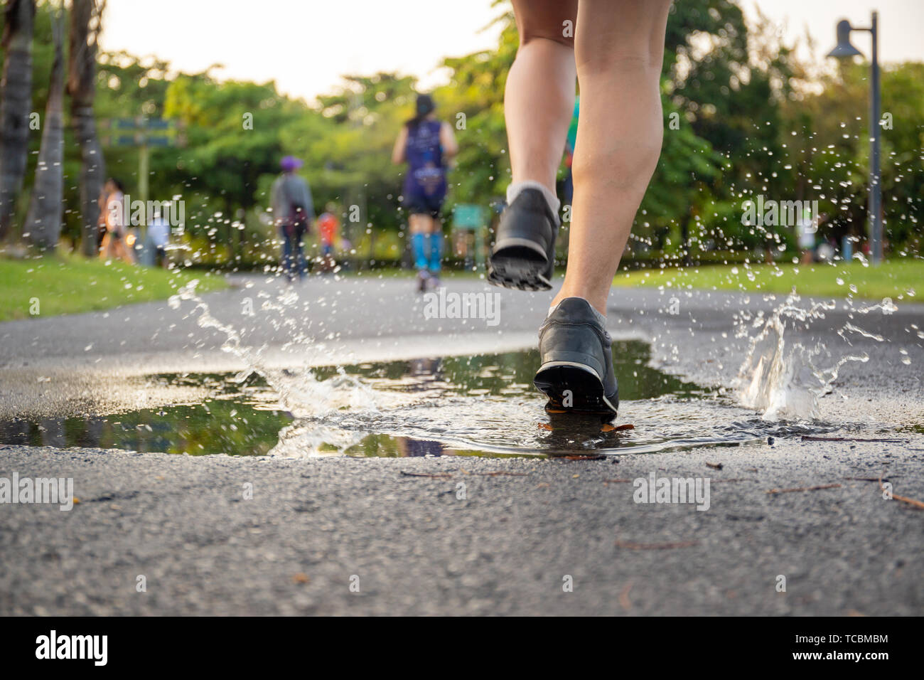 Man exercise running through puddle splashing his shoes Stock Photo - Alamy