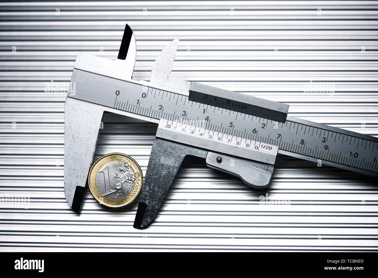 metal gauge measuring a one euro coin on a metal surface Stock Photo ...