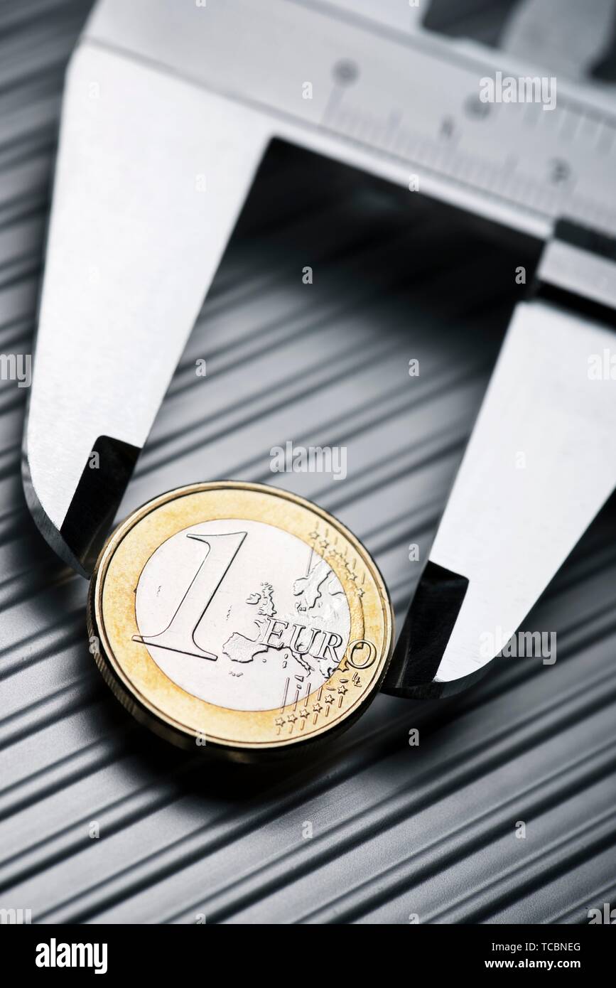metal gauge measuring a one euro coin on a metal surface Stock Photo ...