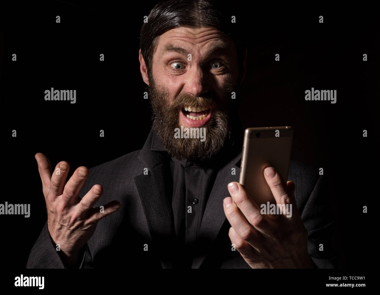 Old believer senior priest with a smartphone, bearded old man is ...