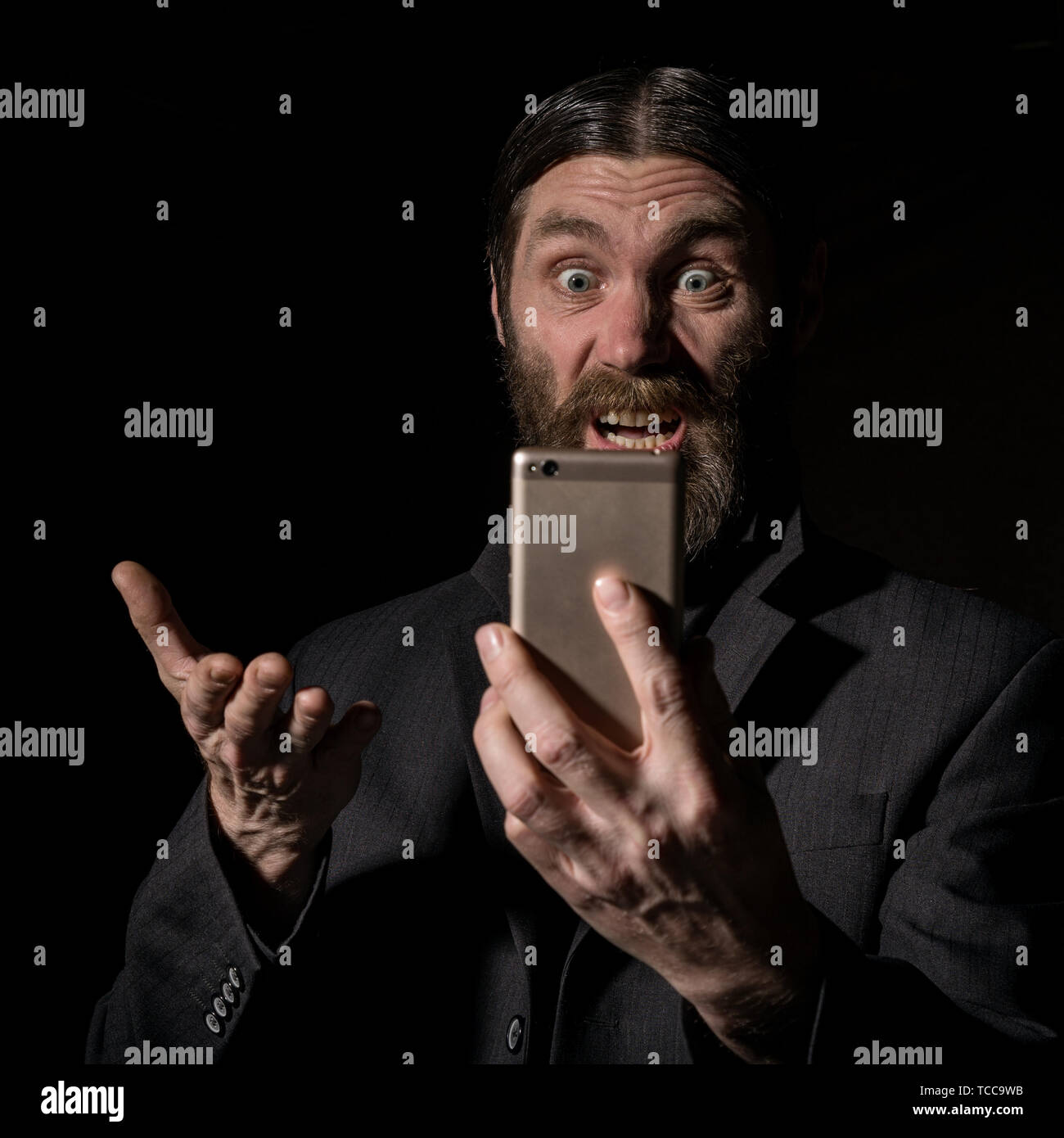 Old believer senior priest with a smartphone, bearded old man is ...