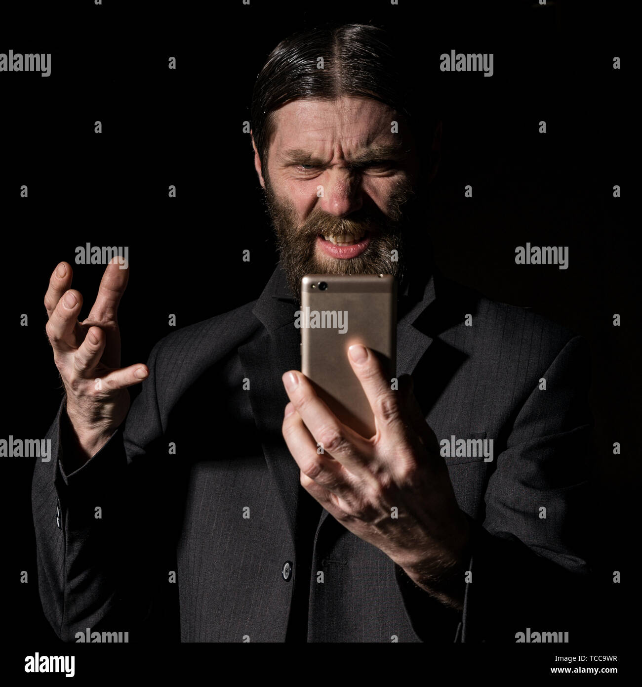 Old believer senior priest with a smartphone, bearded old man is ...
