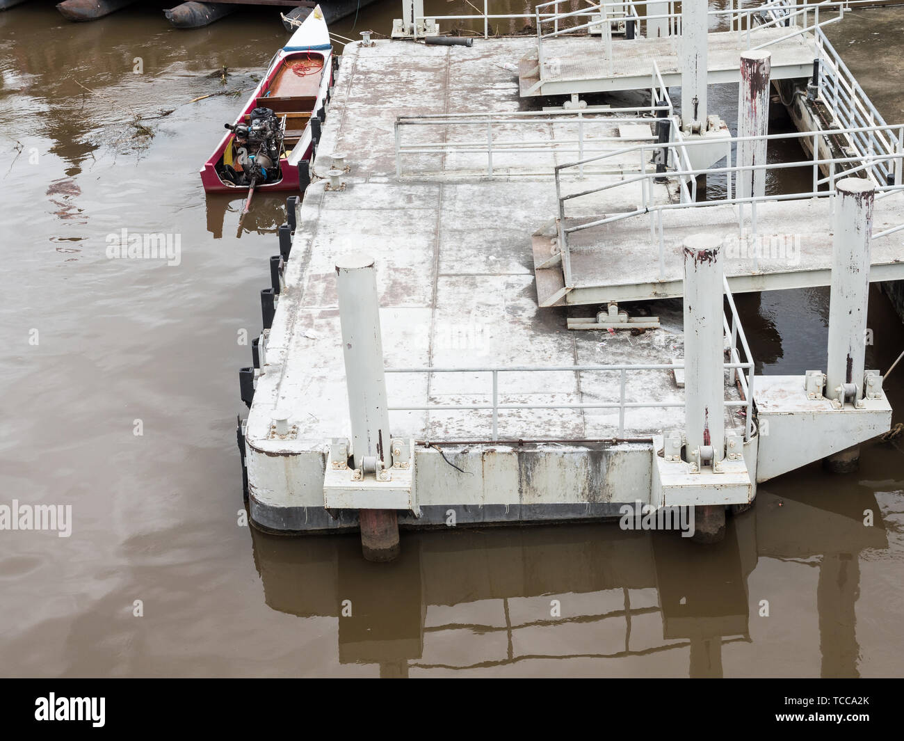 Long tail boat is floating near the concrete pontoon for service the ...