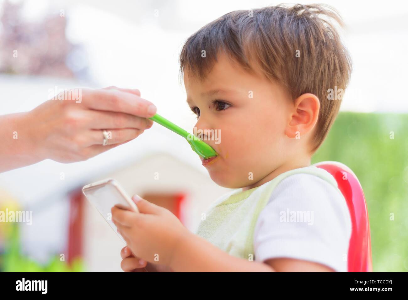 Child smartphone eating hi-res stock photography and images - Alamy