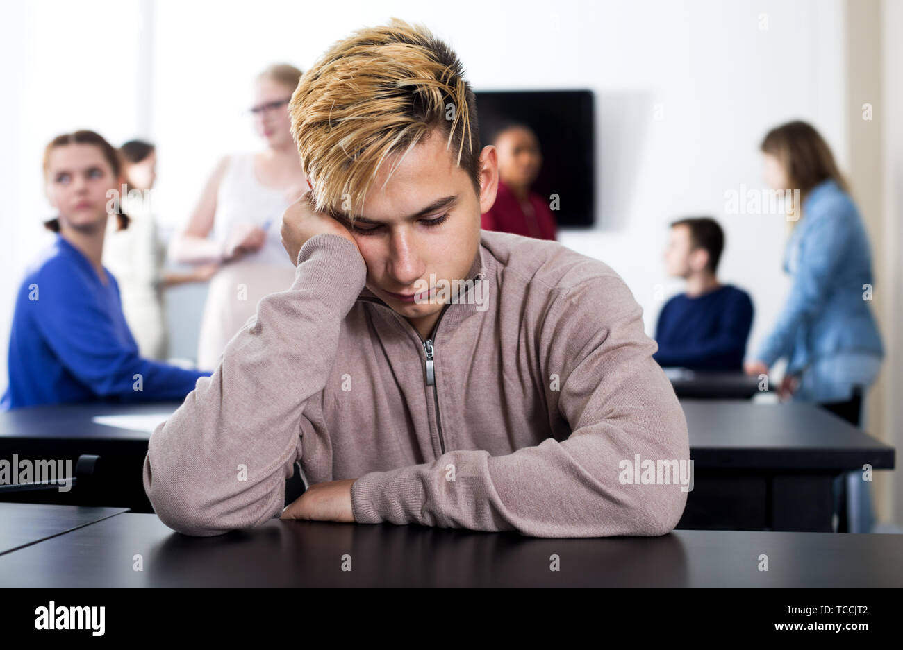 Sad new boy student being shy among classmates at recess in school ...