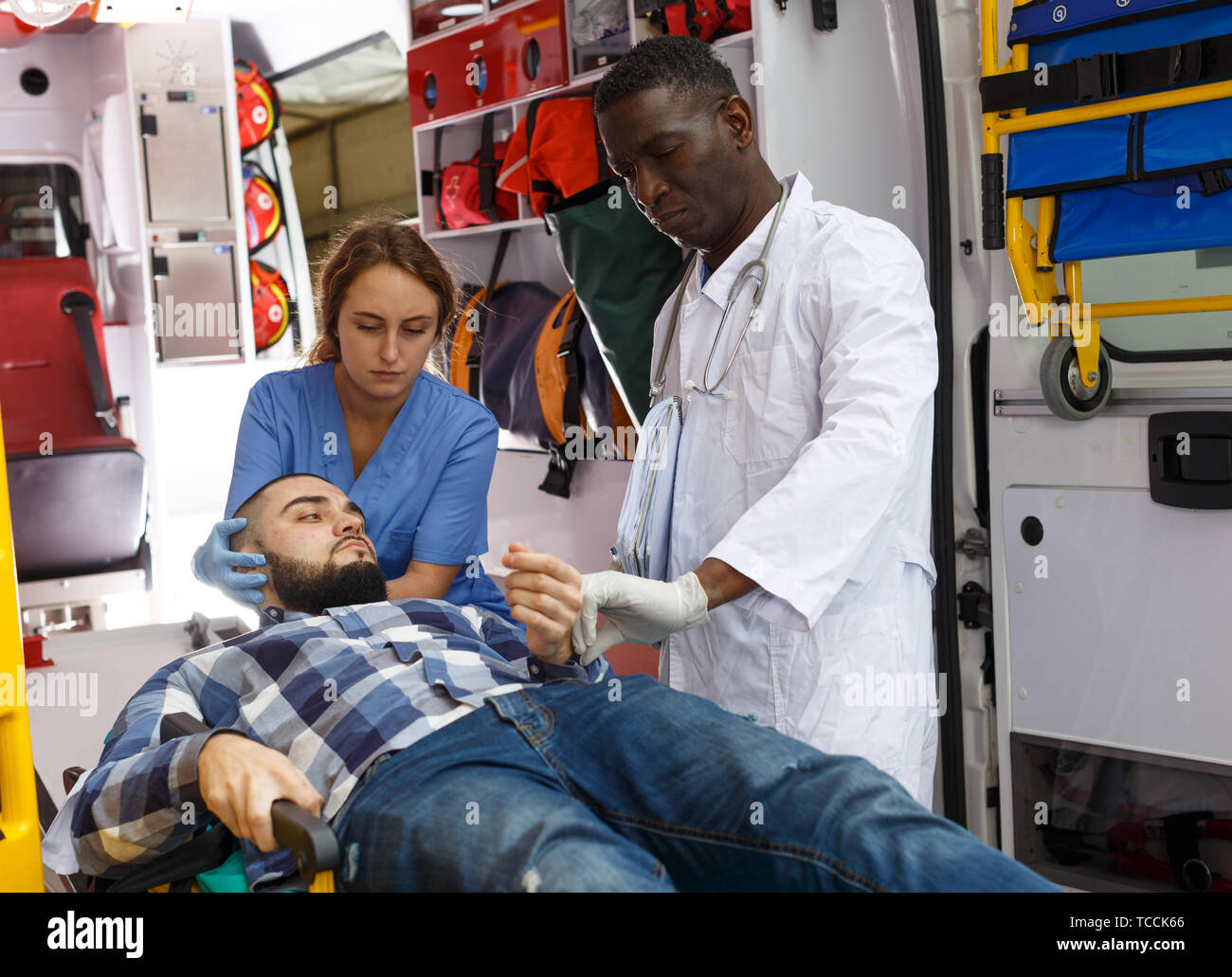 Ambulance team providing medical care to patient on stretcher in ...