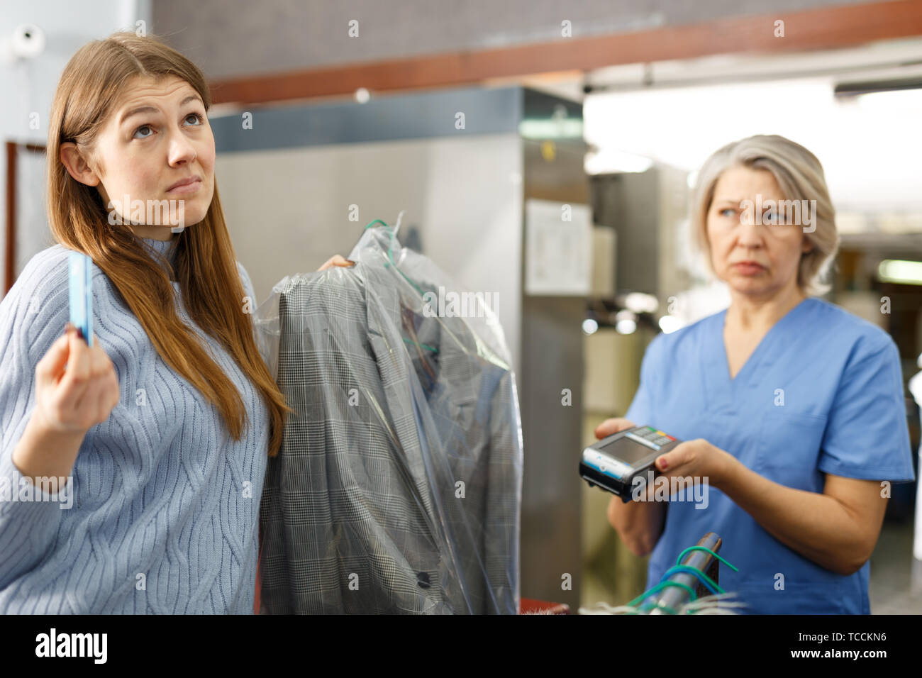 Female customer complaining to dry-cleaning salon worker about high ...
