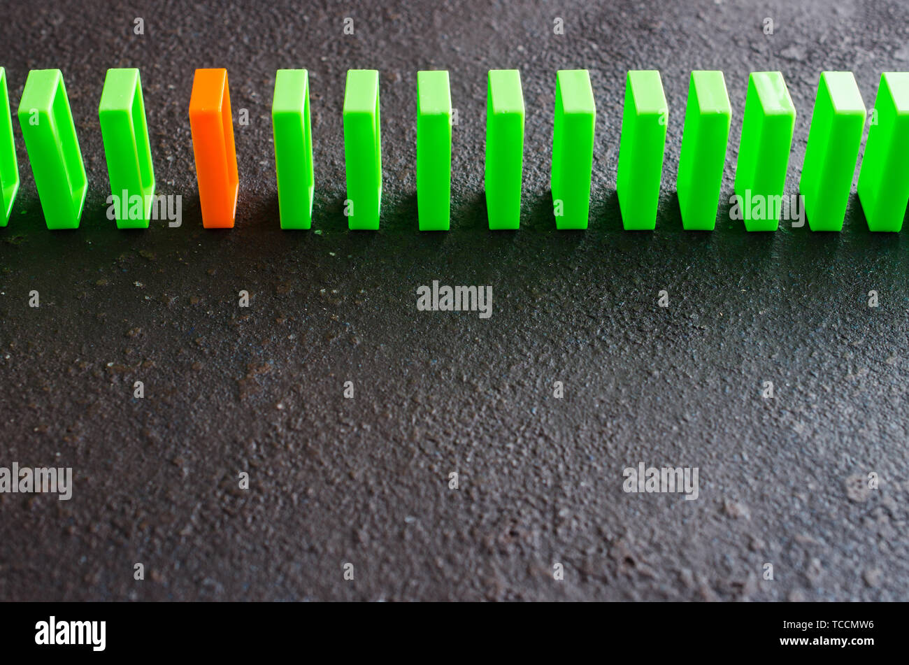 Domino effect - row of green dominoes on dark background. The concept ...