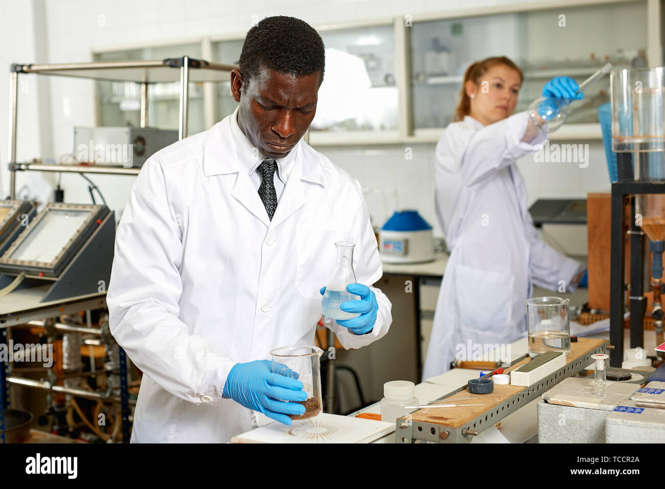 Serious male scientists with glass test tubes during chemical ...