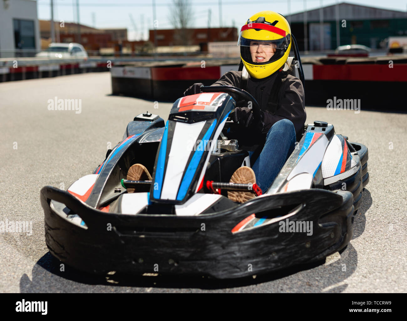Happy cheerful smiling female go-cart racer at kart circuit outdoors ...