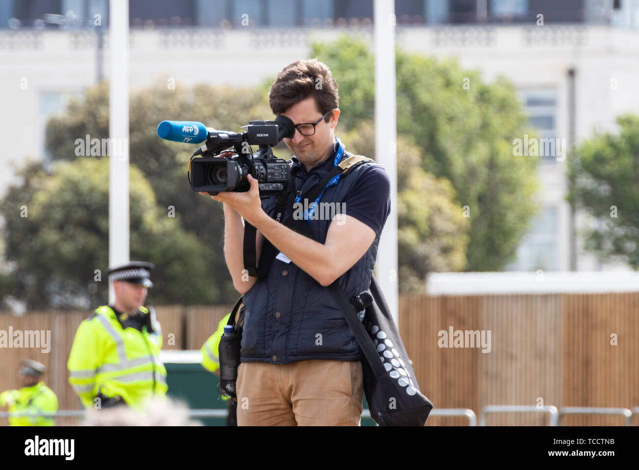 A cameraman holding a camera looking down the lens Stock Photo - Alamy