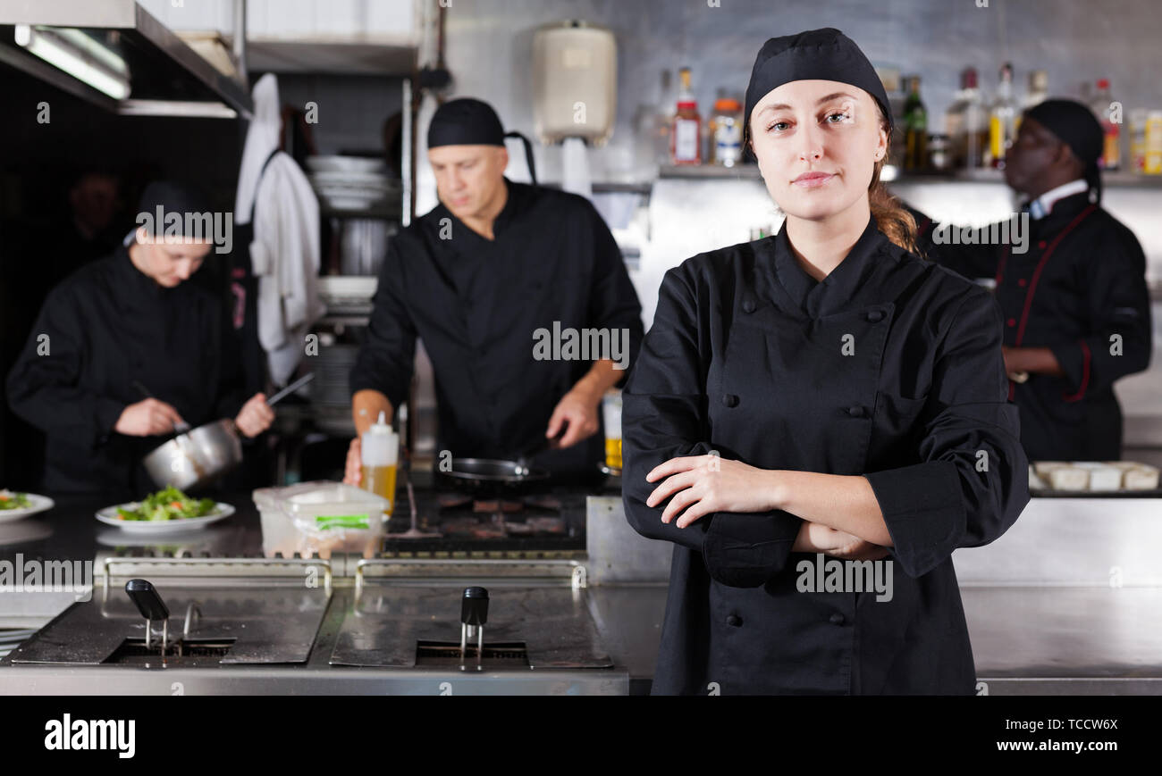 Confident female chef with a team of cooks in restaurant kitchen Stock ...