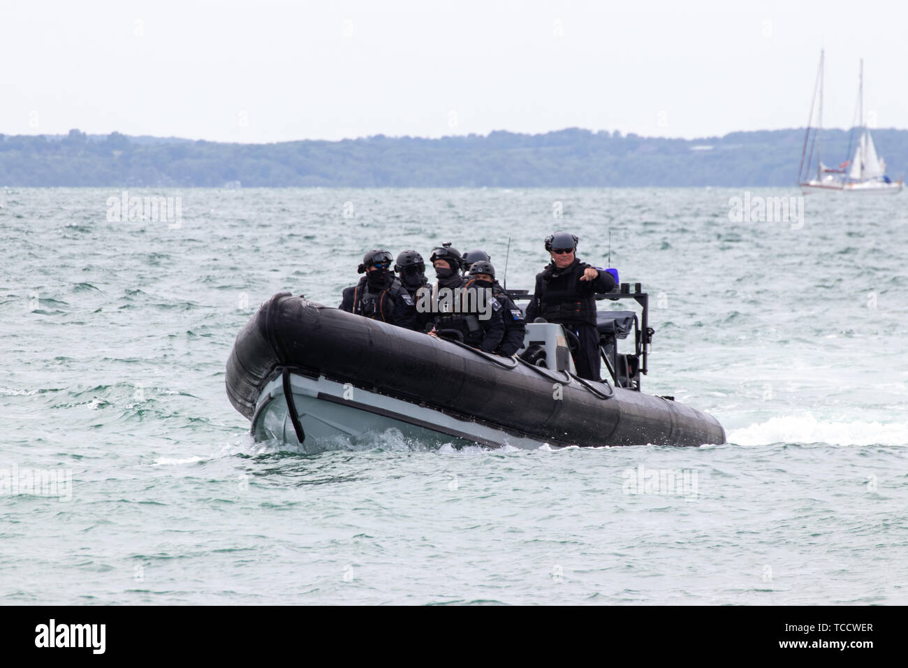 Masked British police officers on a rigid inflatable boat patrolling ...