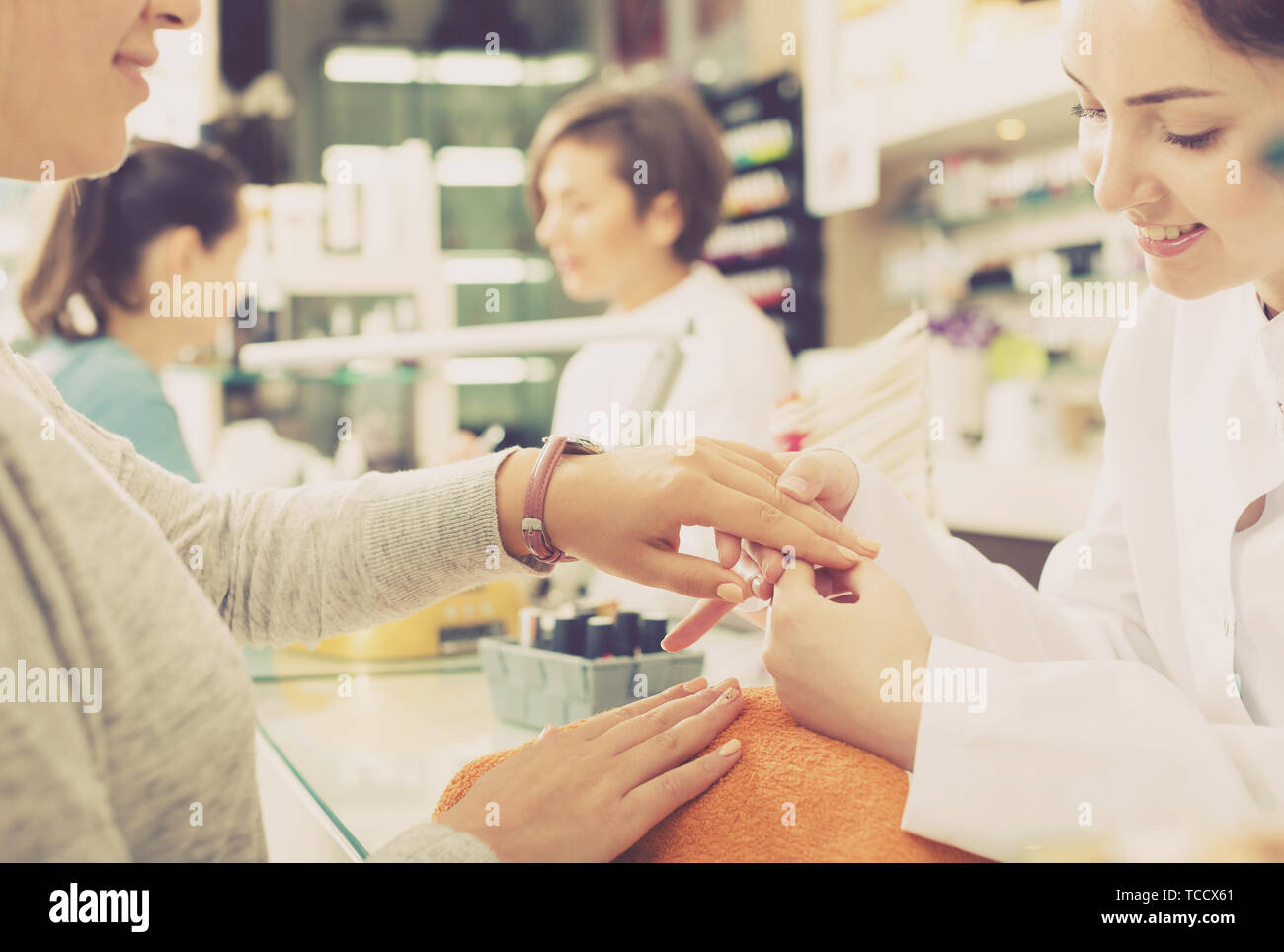 Nail masters performing manicure and massage in beauty salon Stock ...