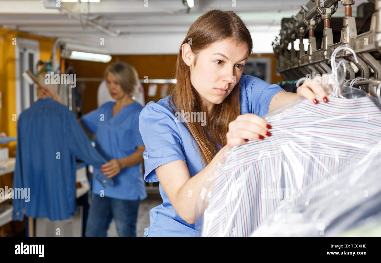 Two women in uniform working at dry-cleaning salon Stock Photo - Alamy
