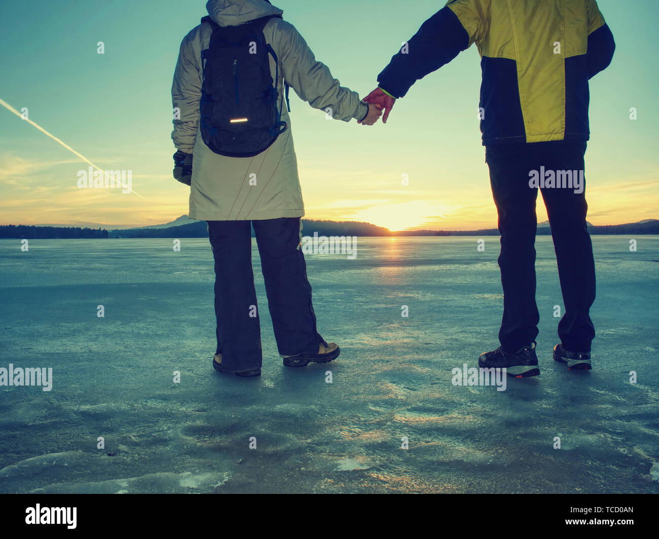 Tourist couple is spending time outdoors on a frozen lake, watching ...