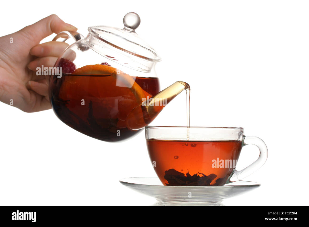 Glass teapot pouring black tea into cup isolated on white Stock Photo ...