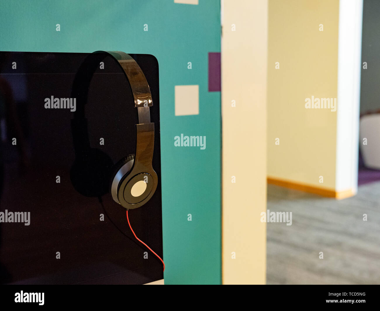 Over ear headphones resting on computer monitor in bright office Stock ...