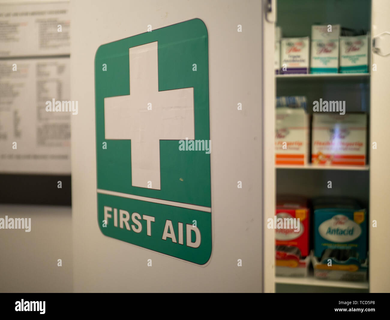 First aid cabinet on an office wall with various pills and medications ...