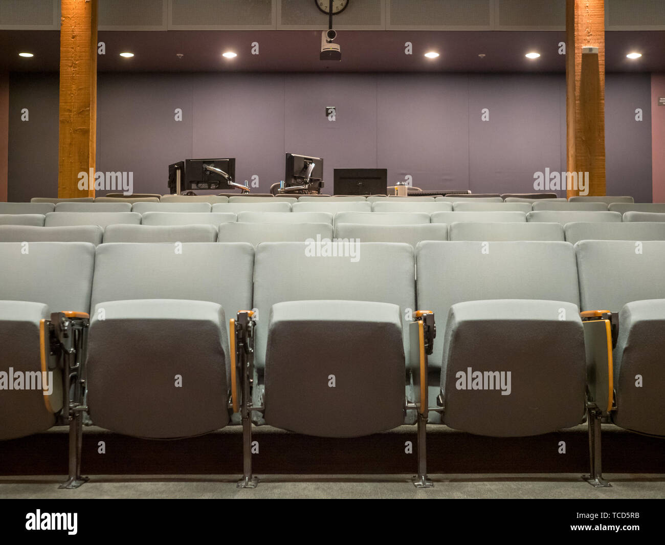 Small office auditorium with gray chairs and computer monitor set up in ...