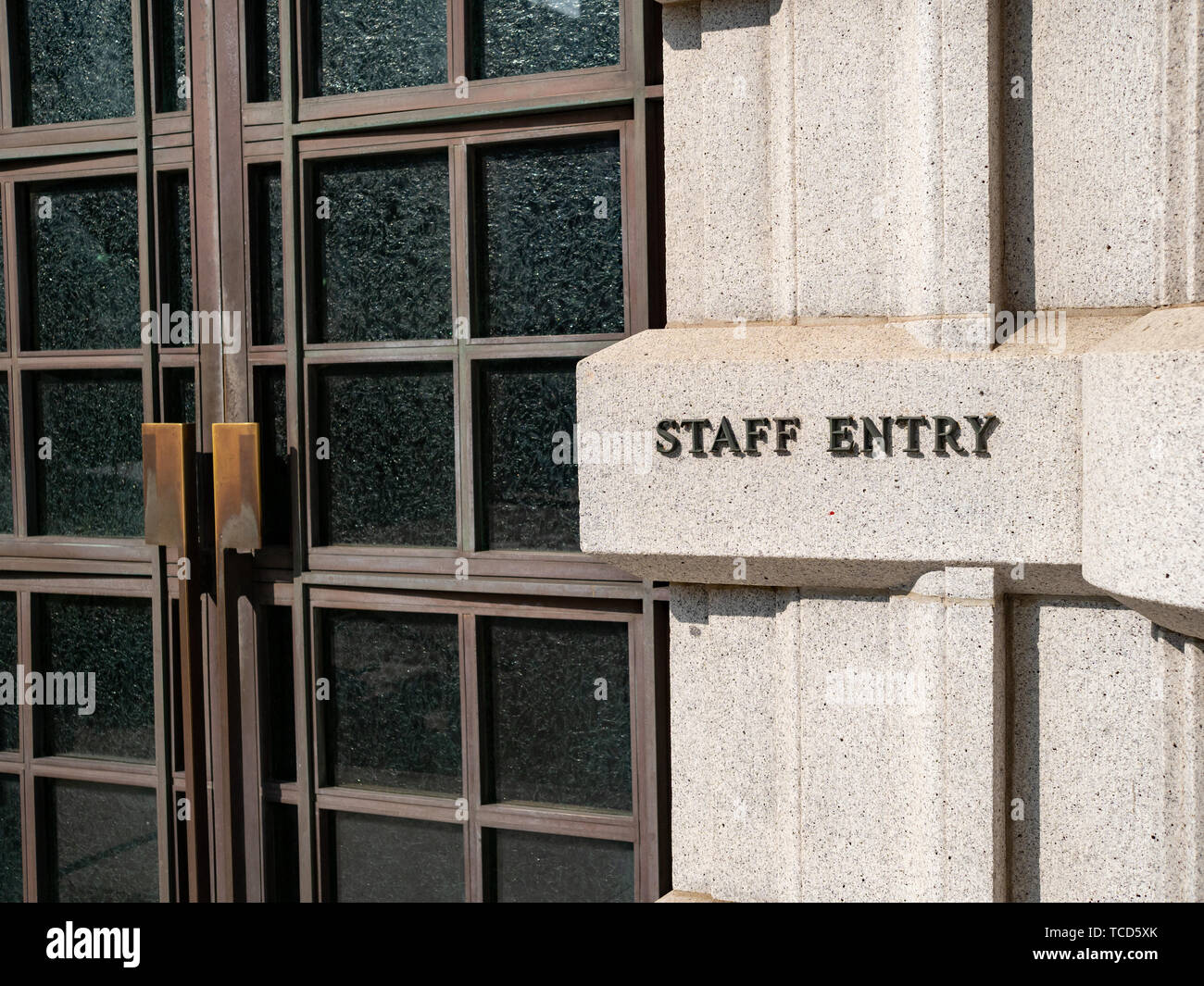 Staff entry sign outside of office building next to double doors Stock ...