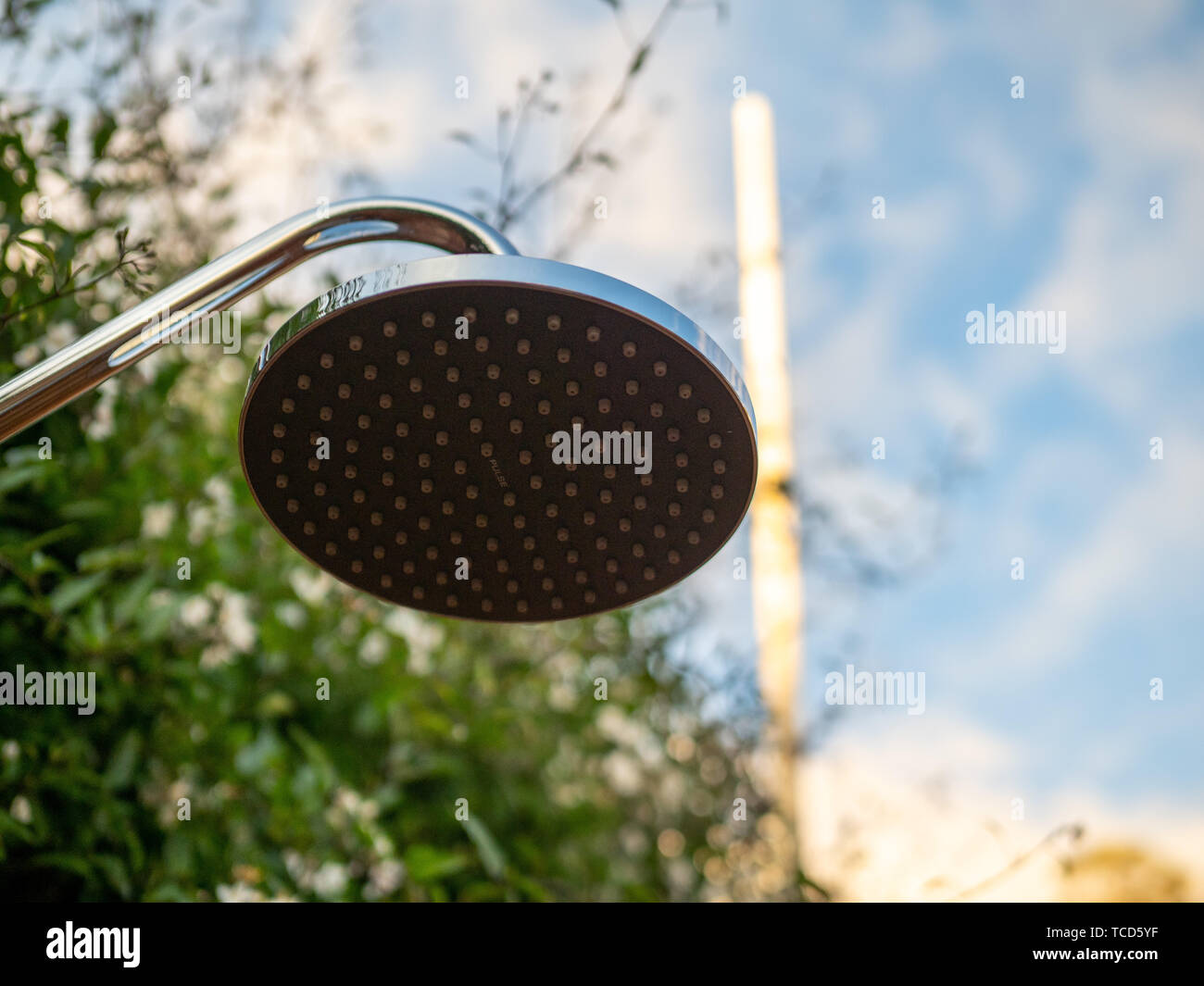 Waterfall showerhead outside in evening sky in an outdoor bath area ...