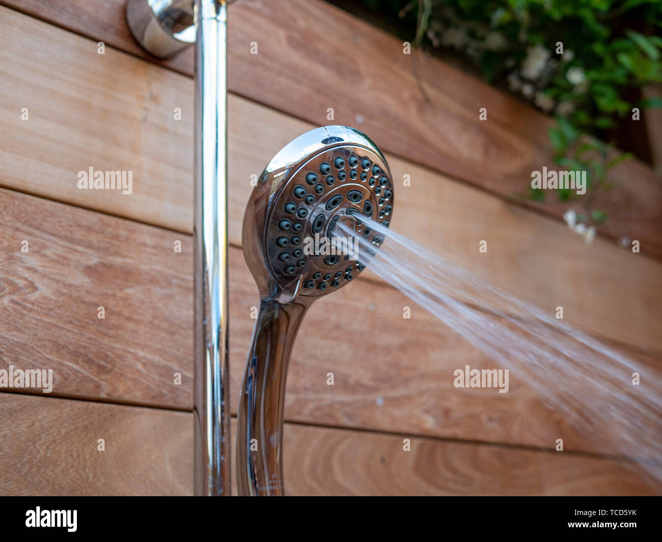 Waterjets flowing out of handheld shower head in outdoor shower Stock ...