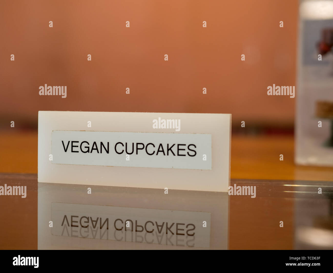 Vegan cupcakes sign sitting on table at counter of vegan bakery Stock ...
