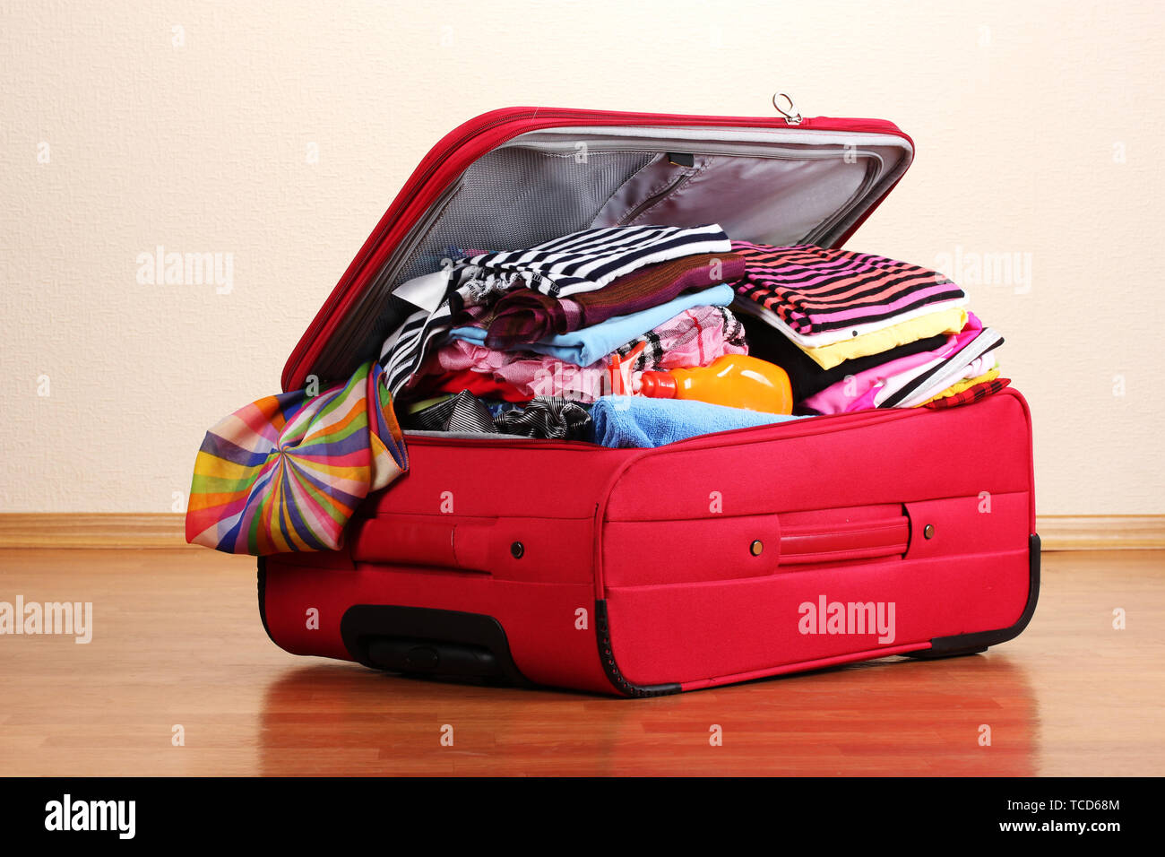 Open red suitcase with clothing in the room Stock Photo - Alamy