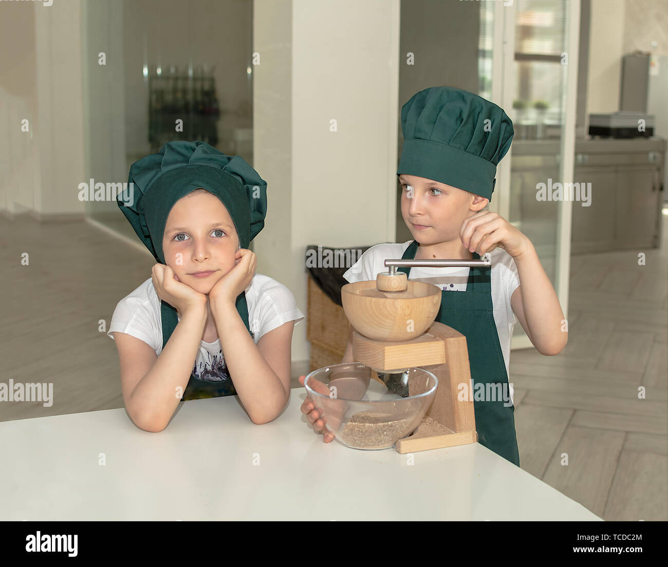 Couple of beautiful young cook chef girls in green chef caps with ...