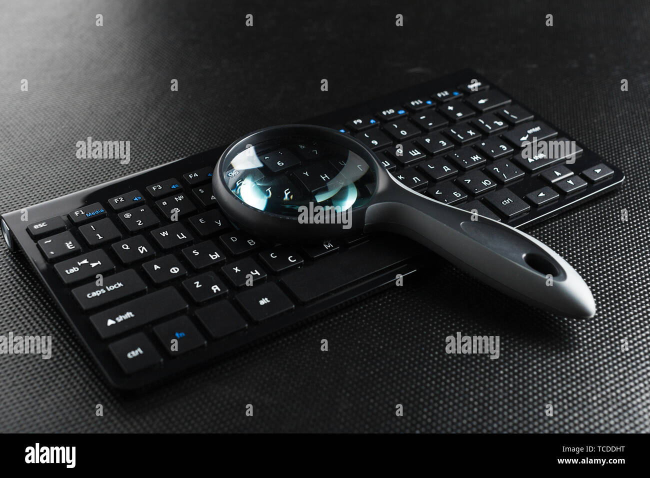 Magnifying Glass on black keyboard Stock Photo - Alamy
