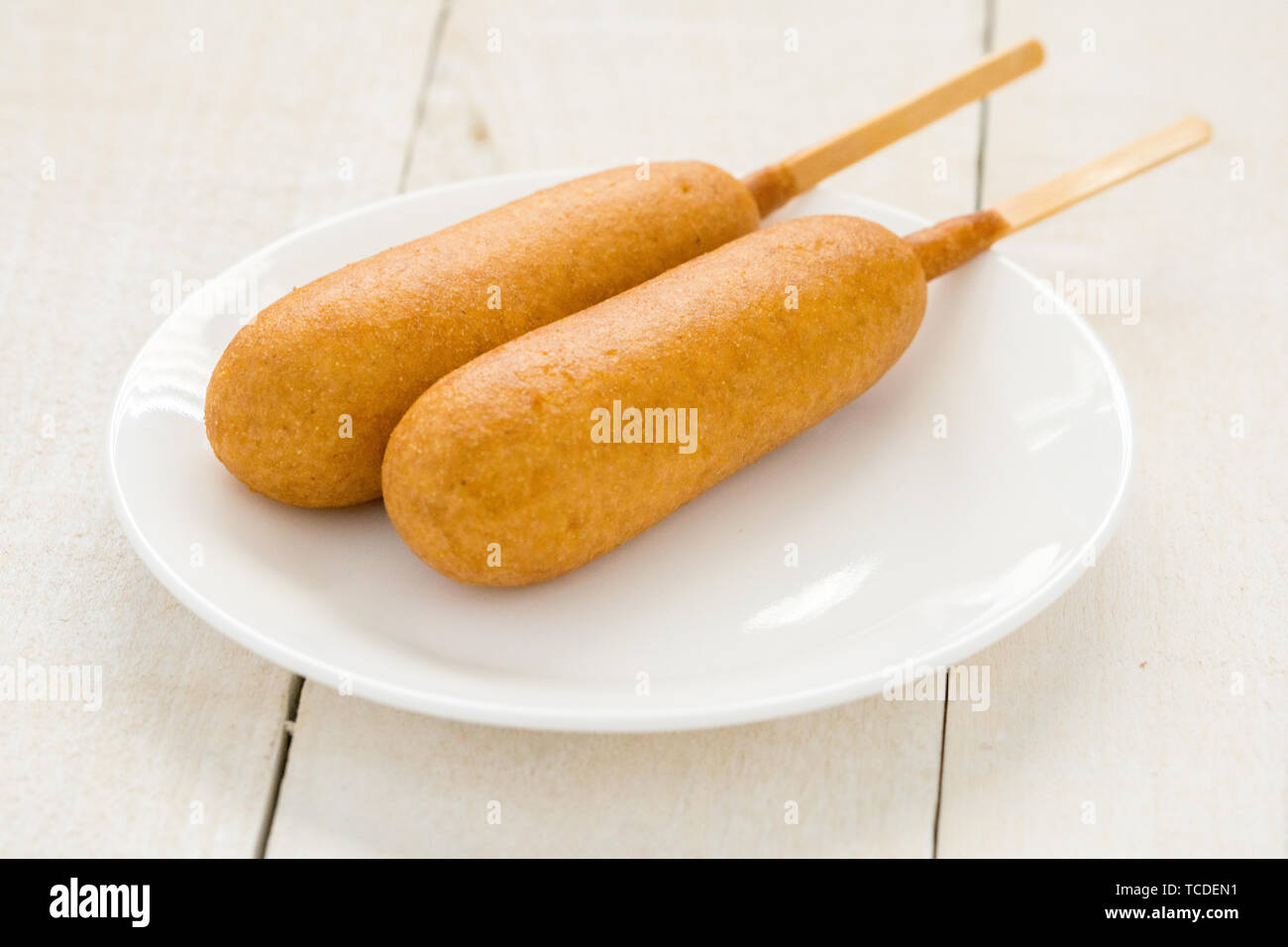 Two corn dogs on white plate Stock Photo - Alamy