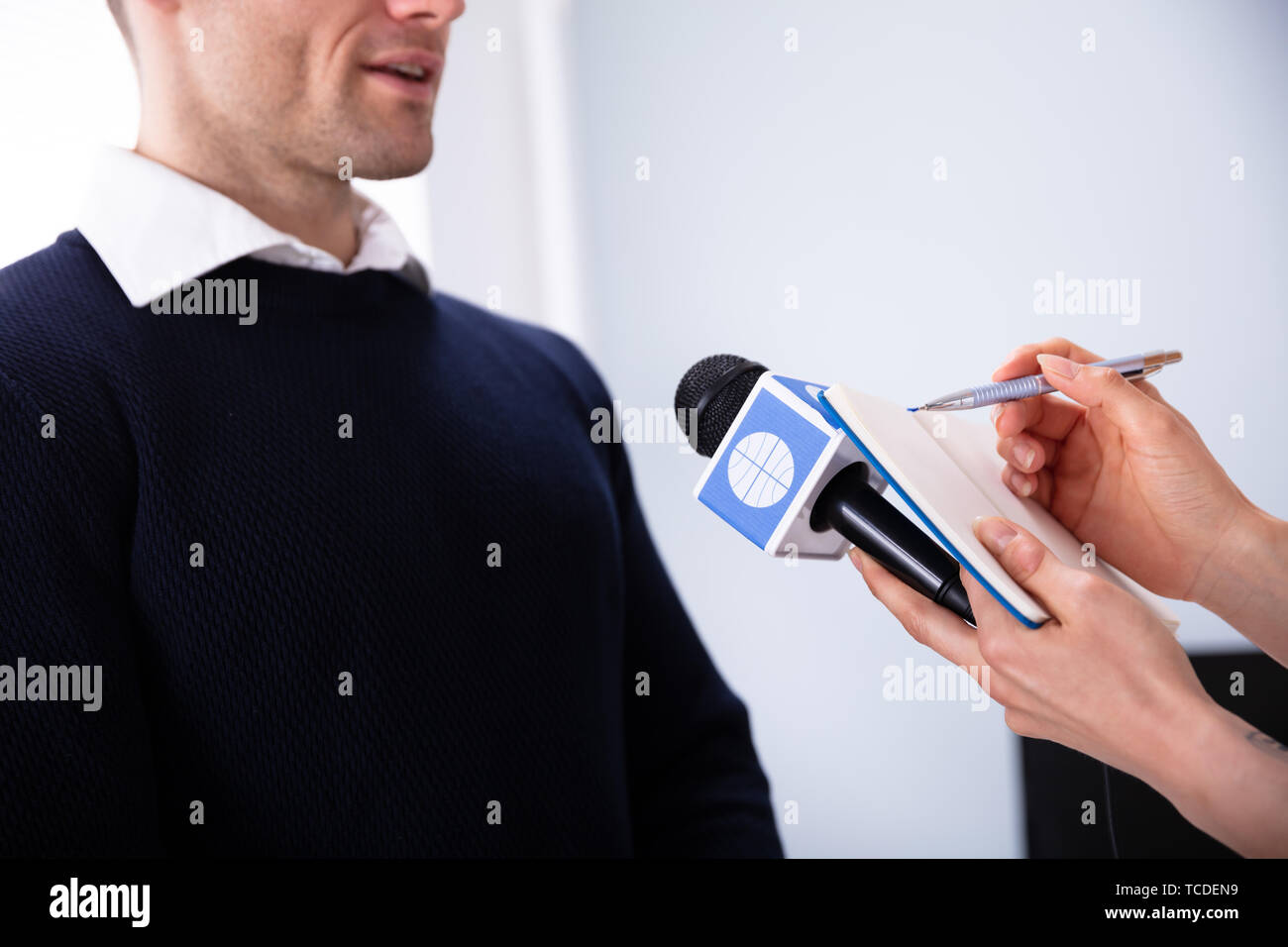 Female Journalist Writing On Diary While Taking An Interview Of ...